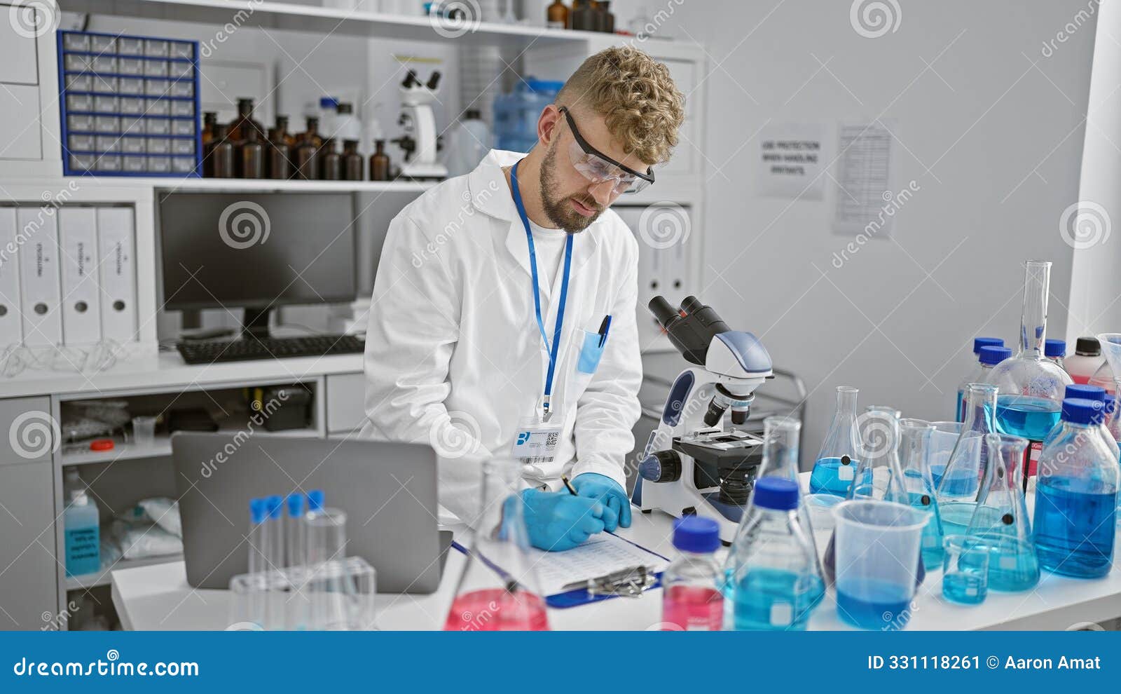 Bearded Scientist in Lab Coat Taking Notes in Modern Laboratory with ...