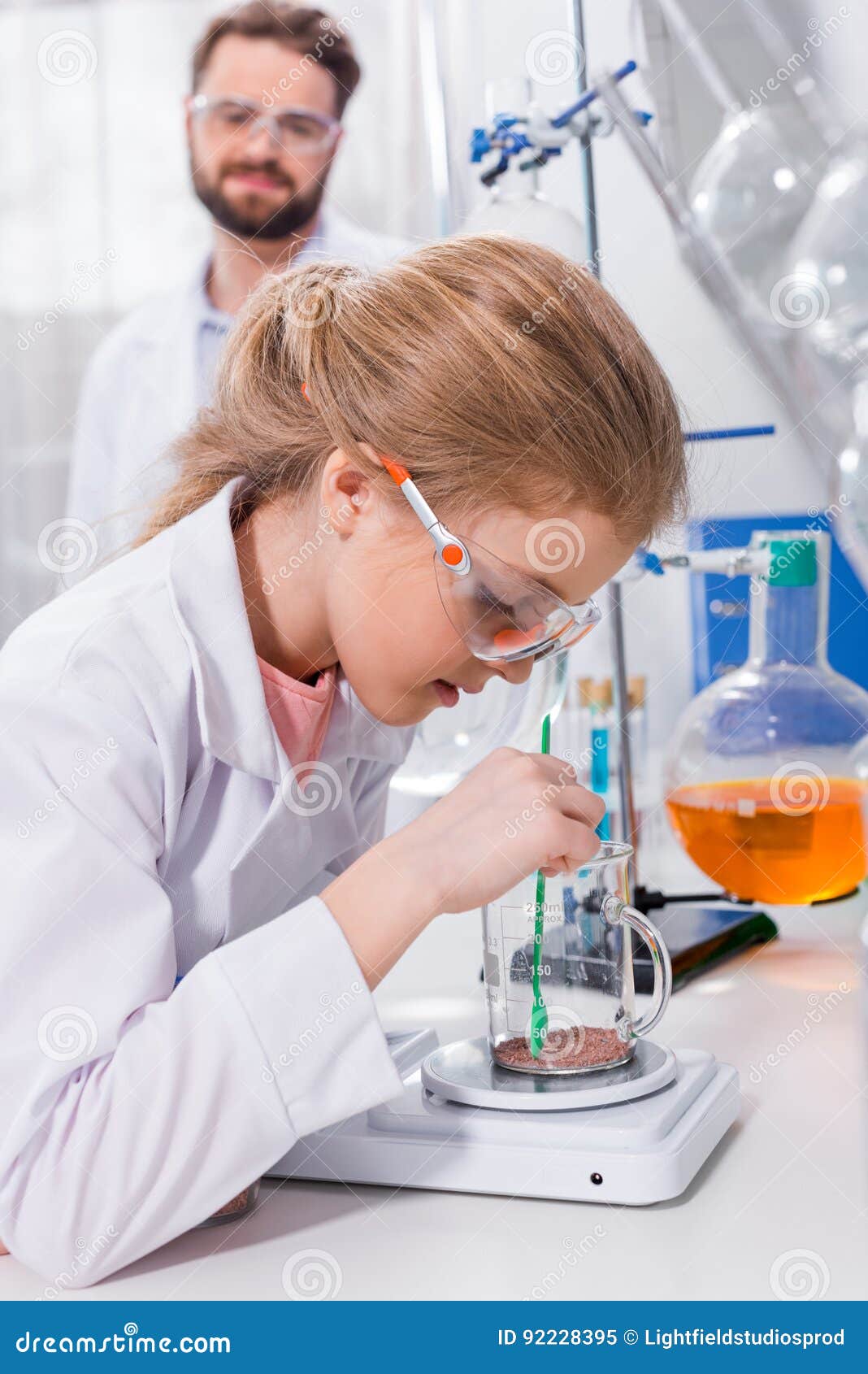 Bearded Teacher Looking at Little Student Making Experiment in ...