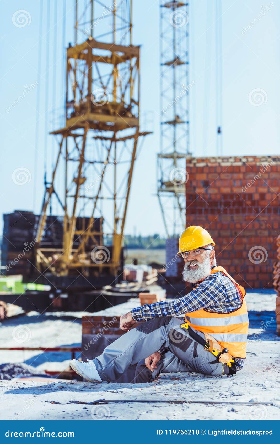 Bearded Worker in Reflective Vest and Hardhat Sitting at Construction ...