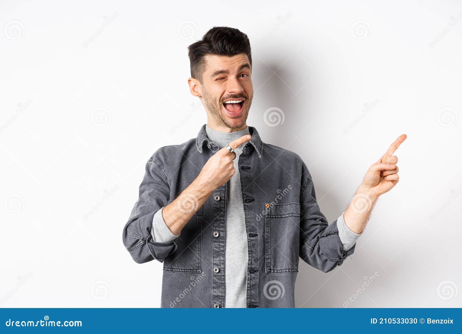Beau Mec Souriant Faisant L'annonce Clin D'oeil Et Pointant Vers Le ... Beau Mec Souriant Faisant L'annonce Clin D'oeil Et Pointant Vers Le ...