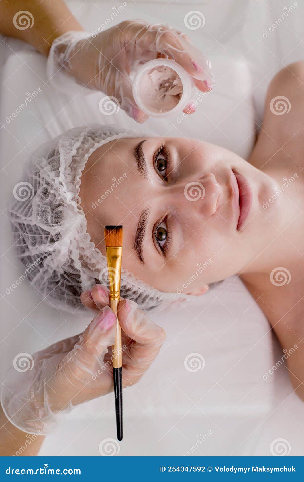 A Beautician Applies A Mask To The Skin Of A Womanand X27 S Face For