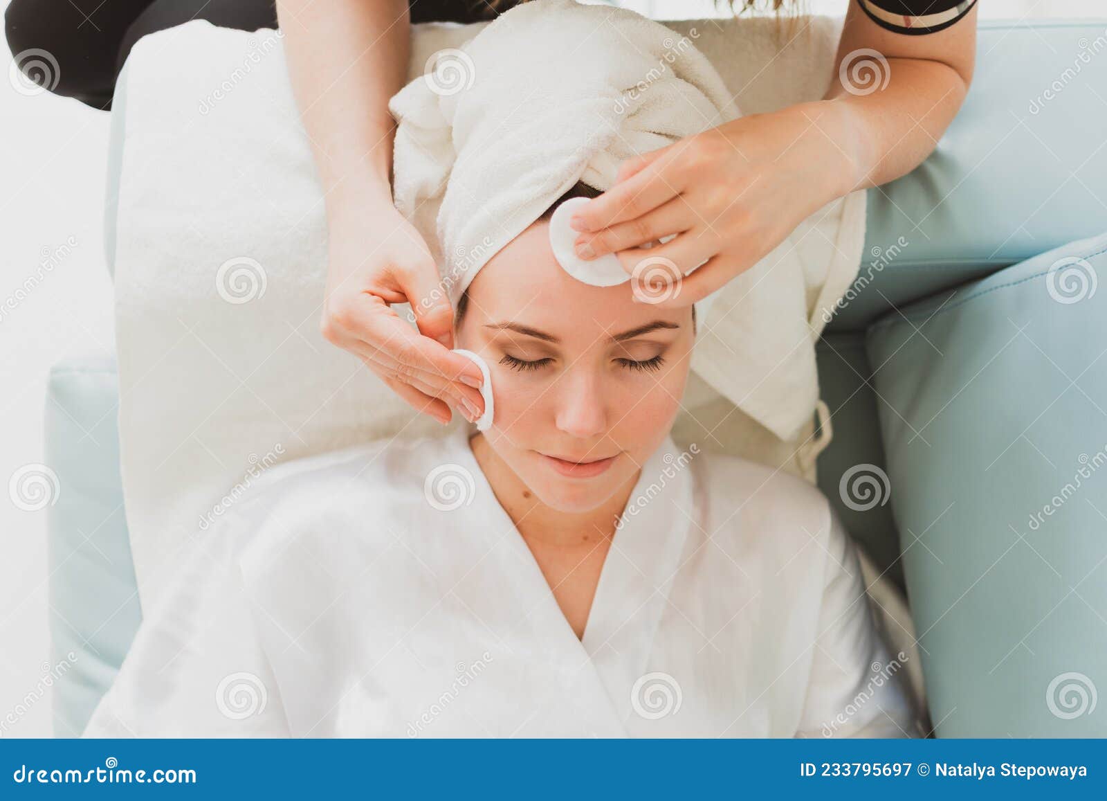 Beautician Makes Facial And Massage To A Young Woman With A Towel On