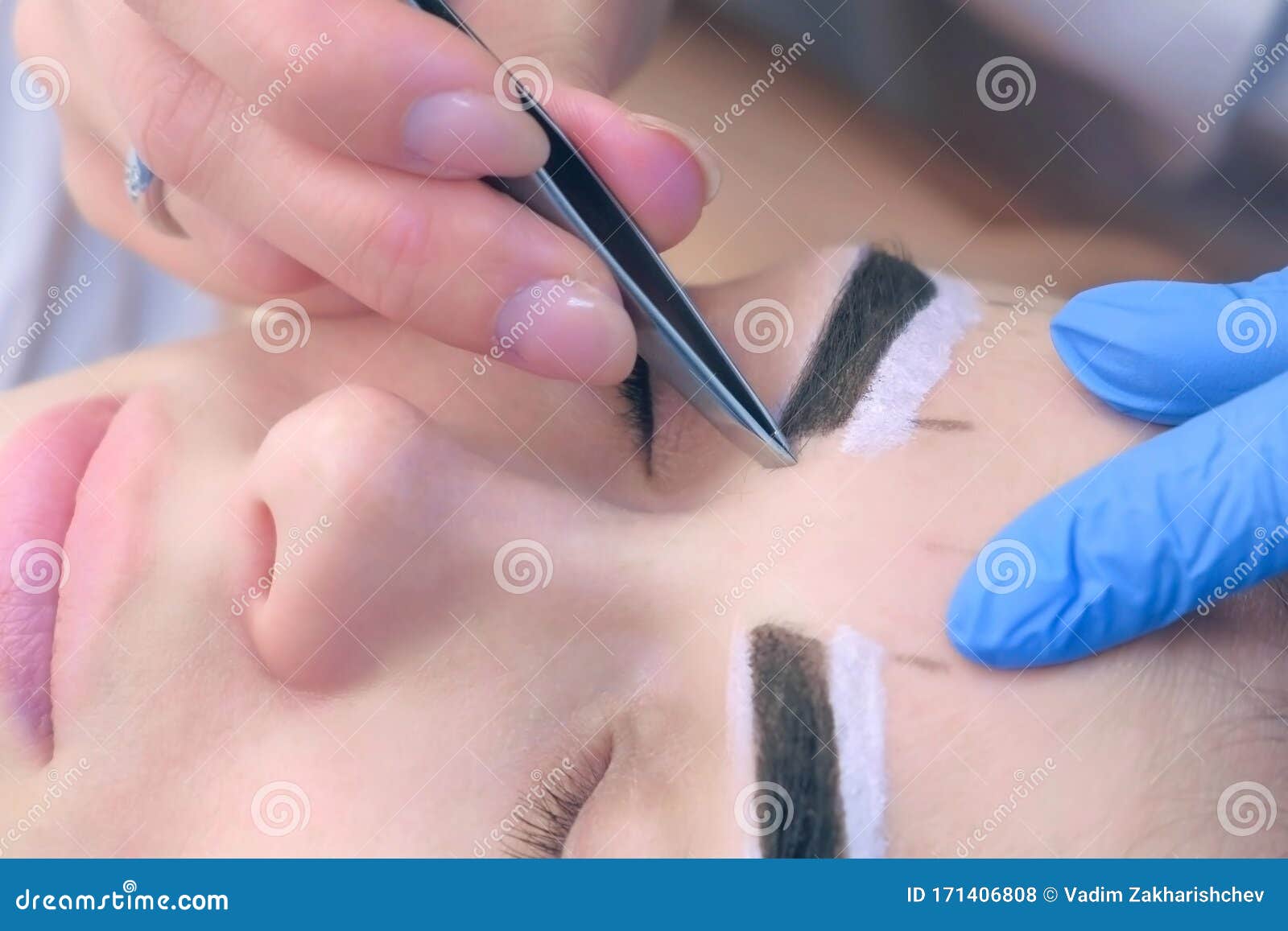 Beautician Plucking Eyebrows With Tweezers To Woman In Beauty Salon