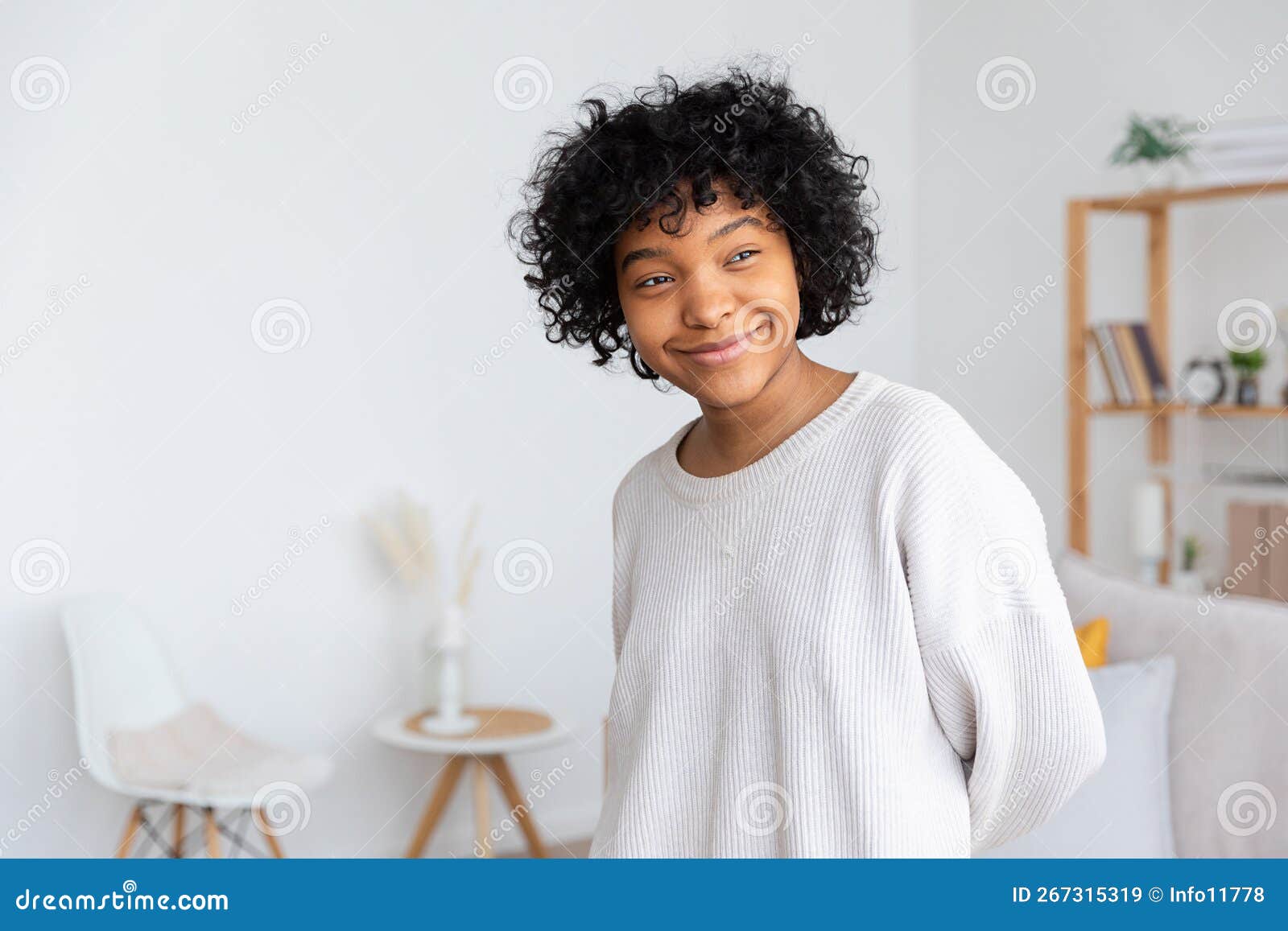Beautiful African American Girl With Afro Hairstyle Smiling At Home