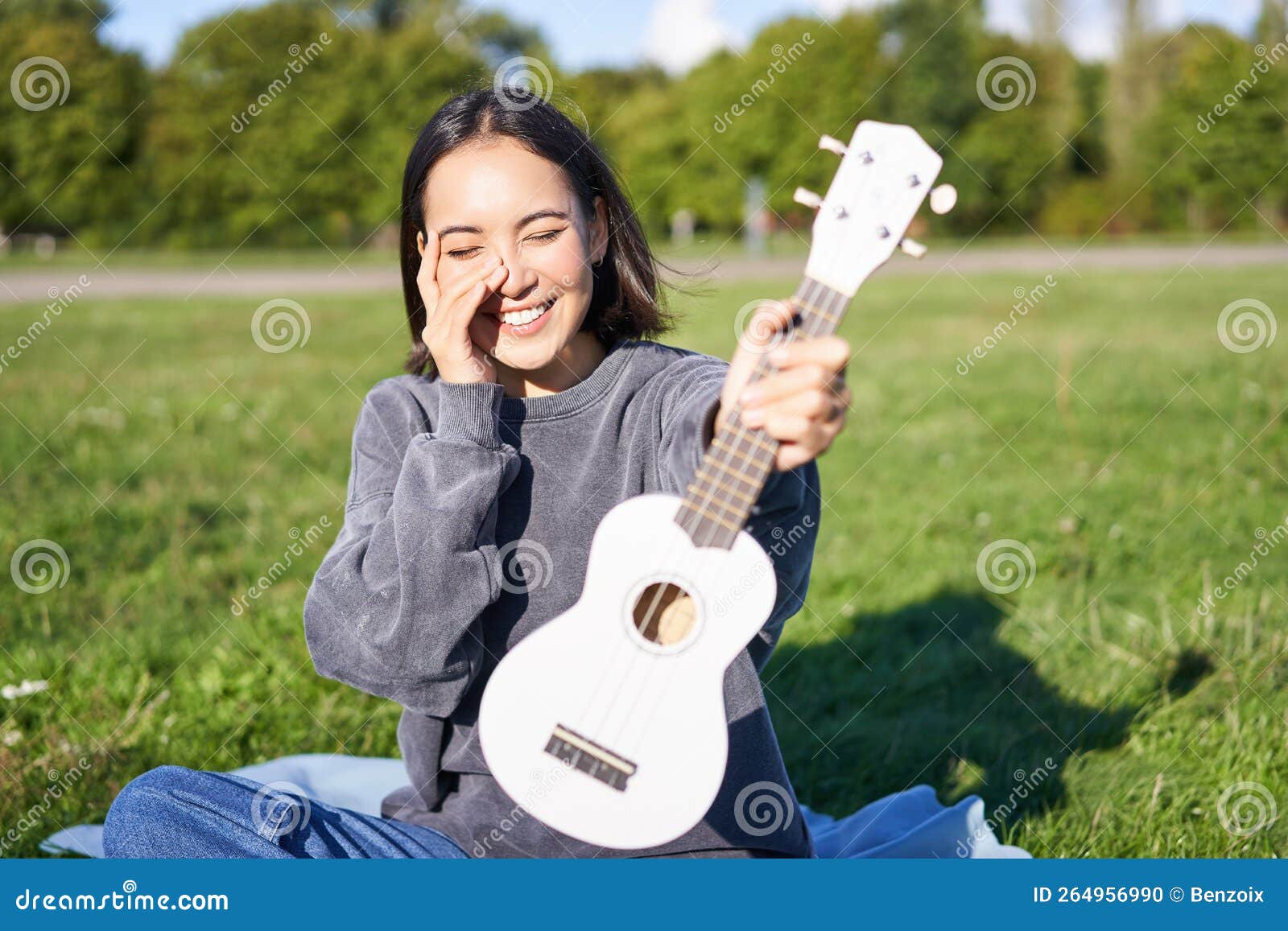 Beautiful Asian Girl With Happy Smile Shows Her Ukulele Sits Outside