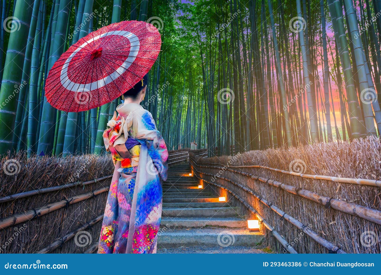 Beautiful Asian Girl In Kimono Holding An Umbrella Visits A Bamboo