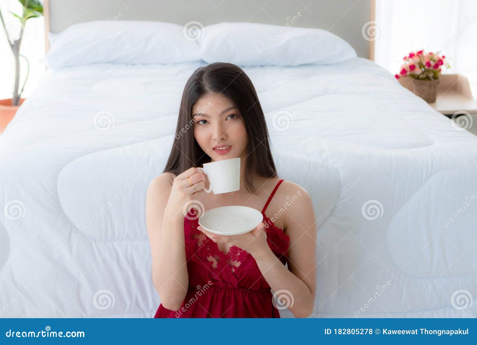 Beautiful Asian Girl Wearing Red Pajamas Sitting In The White Bedroom