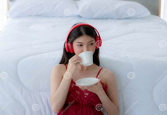 Beautiful Asian Girl Wearing Red Pajamas Sitting In The White Bedroom