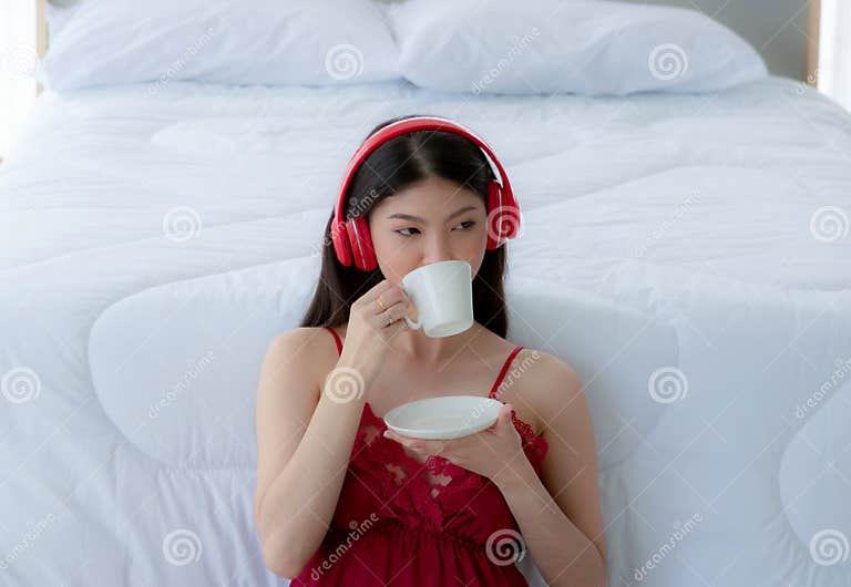 Beautiful Asian Girl Wearing Red Pajamas Sitting In The White Bedroom