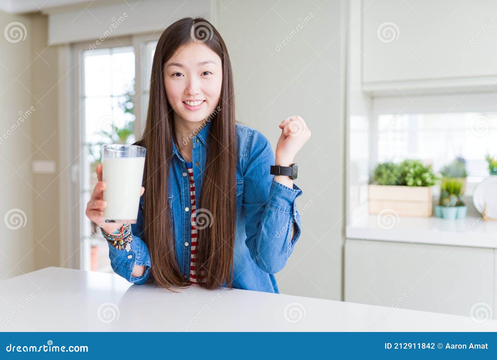 Beautiful Asian Woman Drinking A Fresh Glass Of Milk Screaming Proud