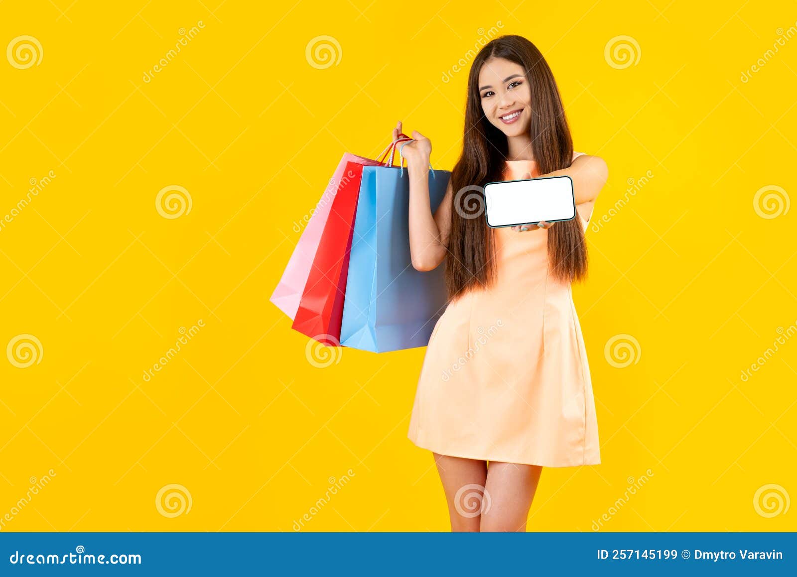 Beautiful Asian Woman Holding Shopping Bags And Smartphone With Empty