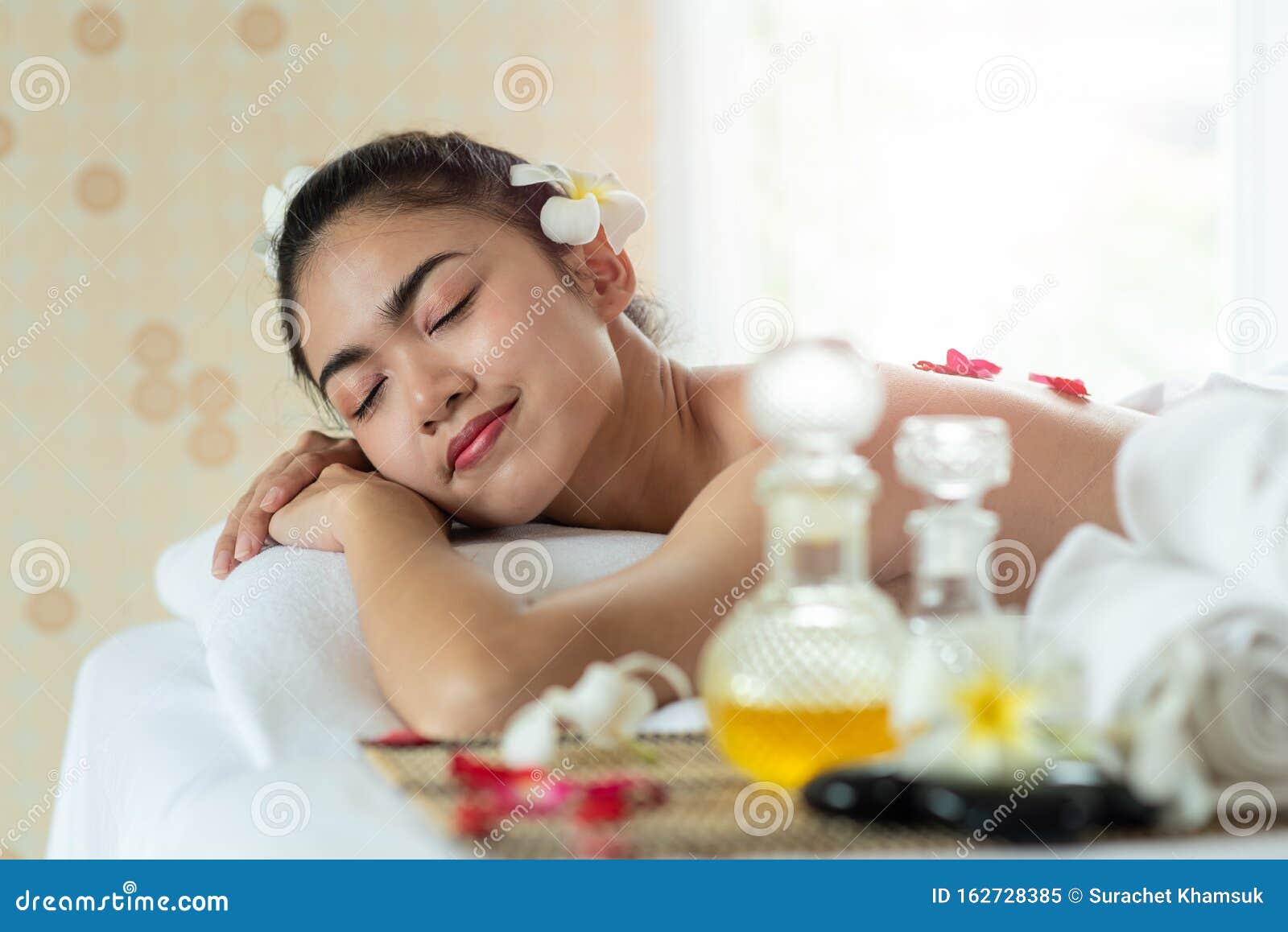Beautiful Asian Woman Lying Down On Massage Bed Relaxing In Spa Salon