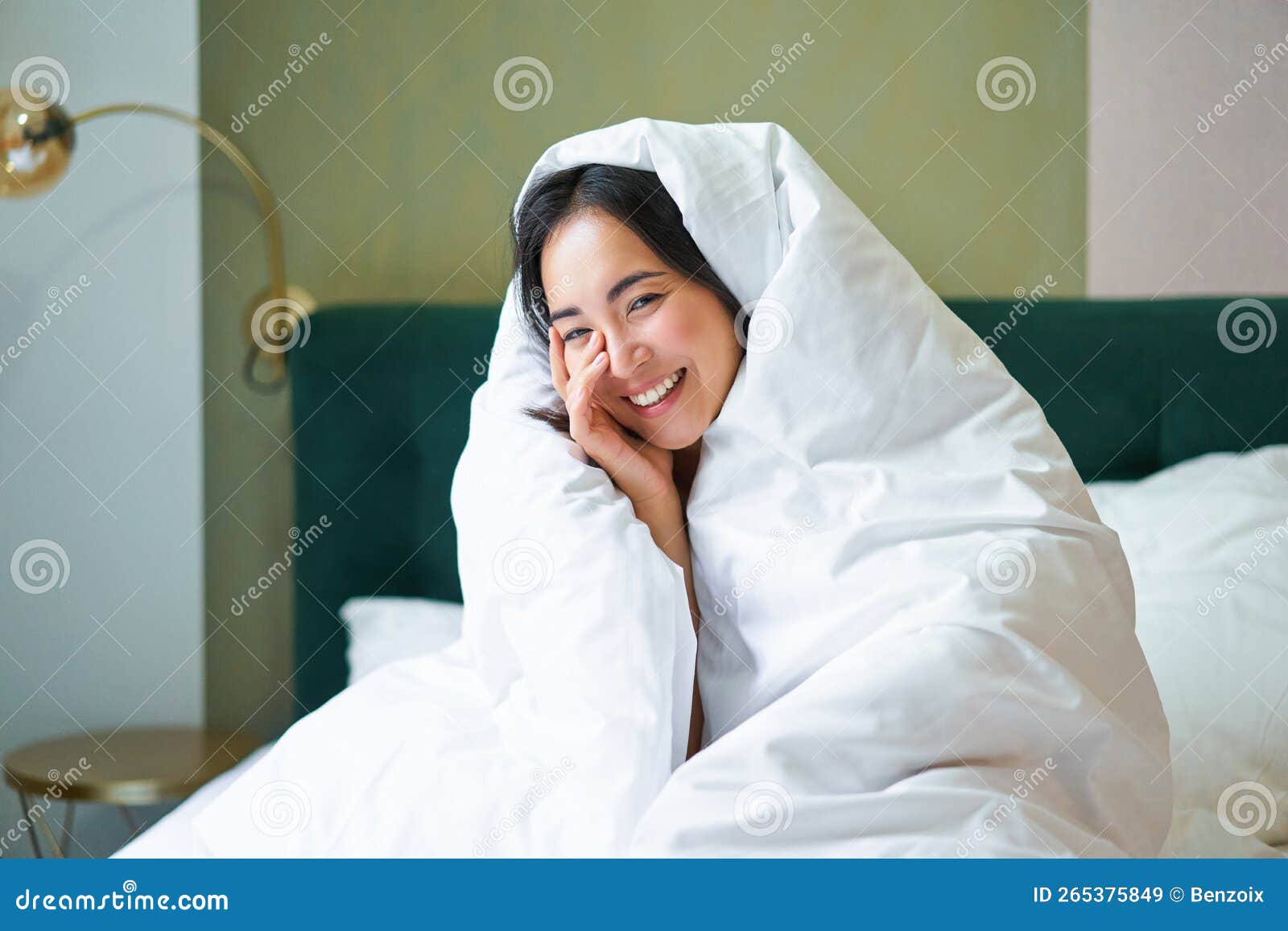 Beautiful Asian Woman Sitting On Bed Covered In Blankets And Duvet