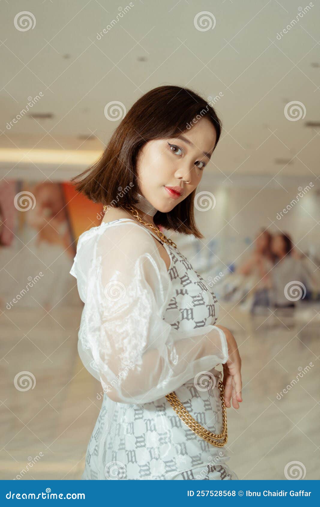 Beautiful Asian Woman in a White Dance Costume with a Golden Chain and ... Beautiful Asian Woman in a White Dance Costume with a Golden Chain and ...