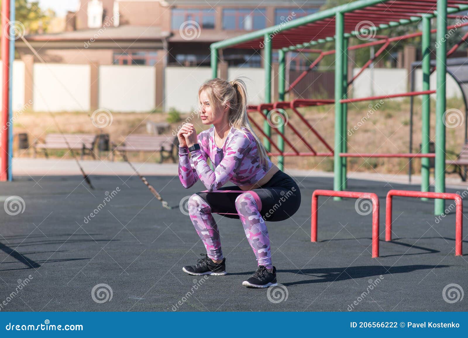 Beautiful And Athletic Blonde Girl Doing Squats On The Street Sports