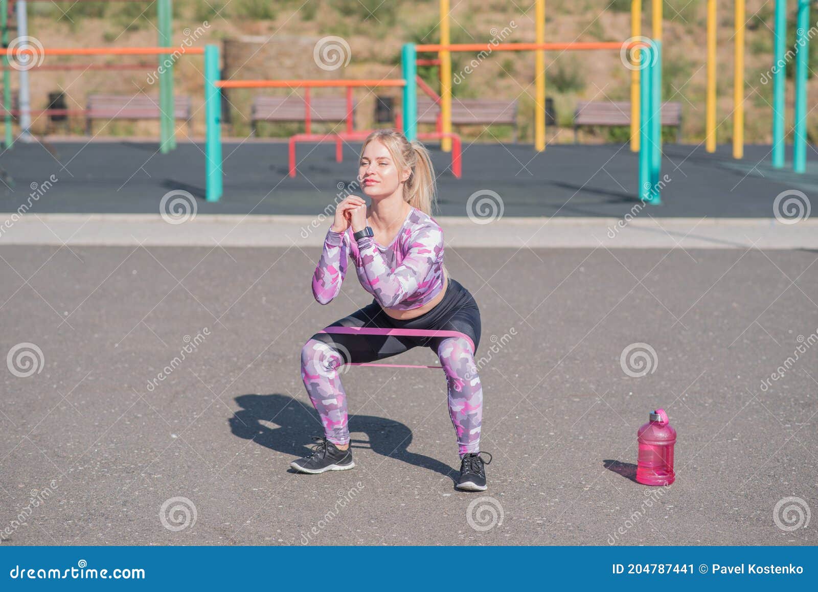 Beautiful And Athletic Blonde Girl Doing Squats On The Street Sports