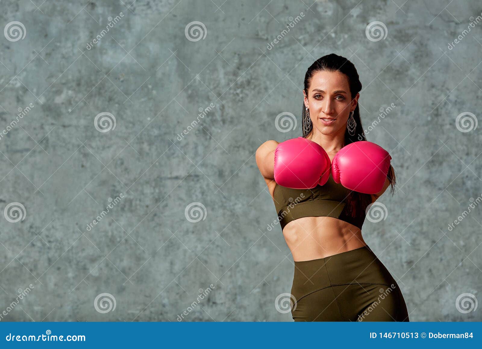 Beautiful Athletic Girl Posing In Pink Boxing Gloves On A Gray