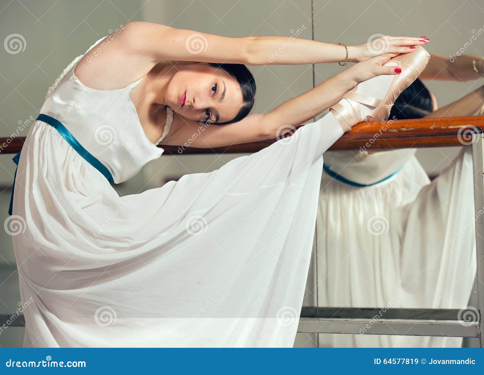 Beautiful Ballet Dancer In White Tutu Posing On One Leg Next To Handle