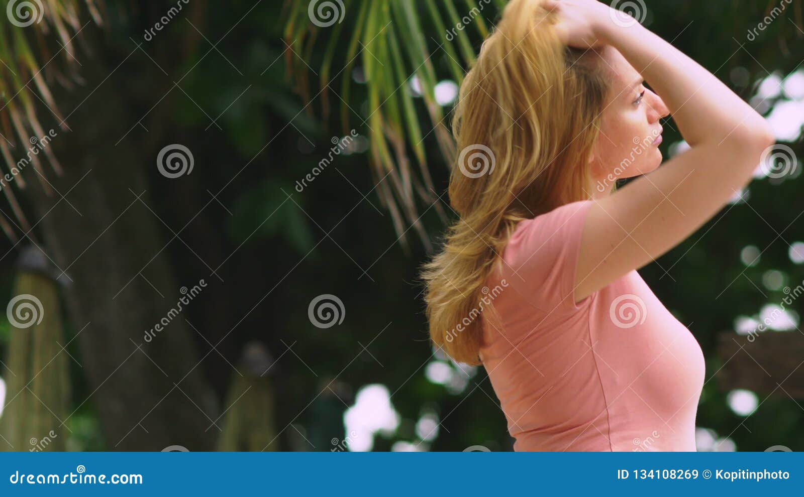 Beautiful Blond Woman Touches Her Hair In Nature Back View Stock Image