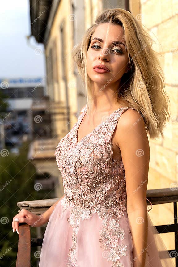 Beautiful Blonde Girl In Evening Dress Standing On The Balcony Stock