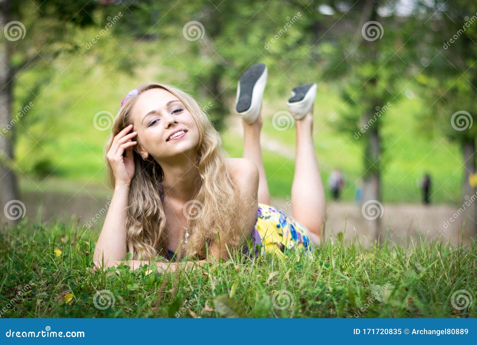 Beautiful Blonde Girl Lying In The Grass And Smiling Stock Image