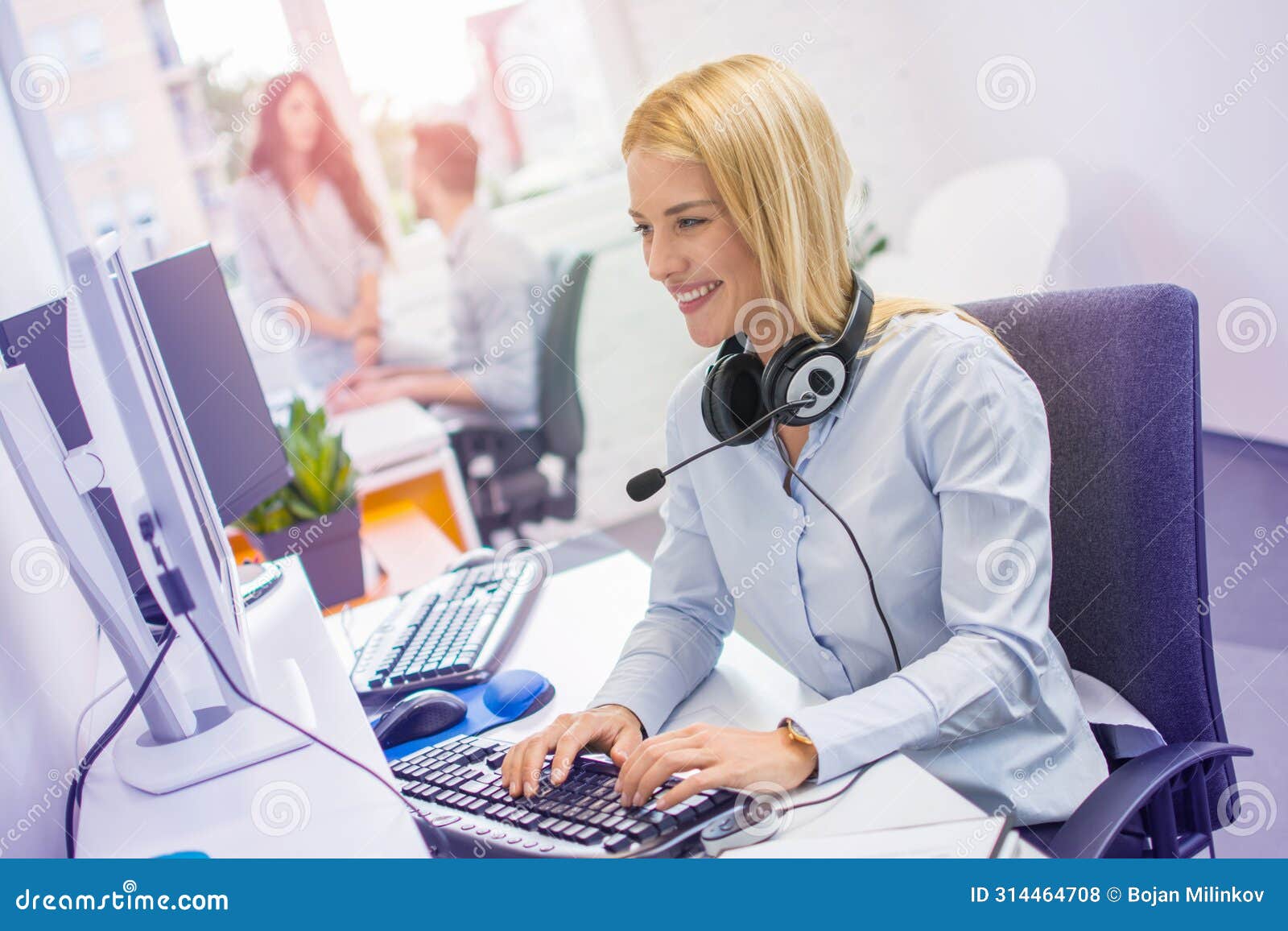 Beautiful Blonde Haired Female Helpline Operator Using Computer at ...