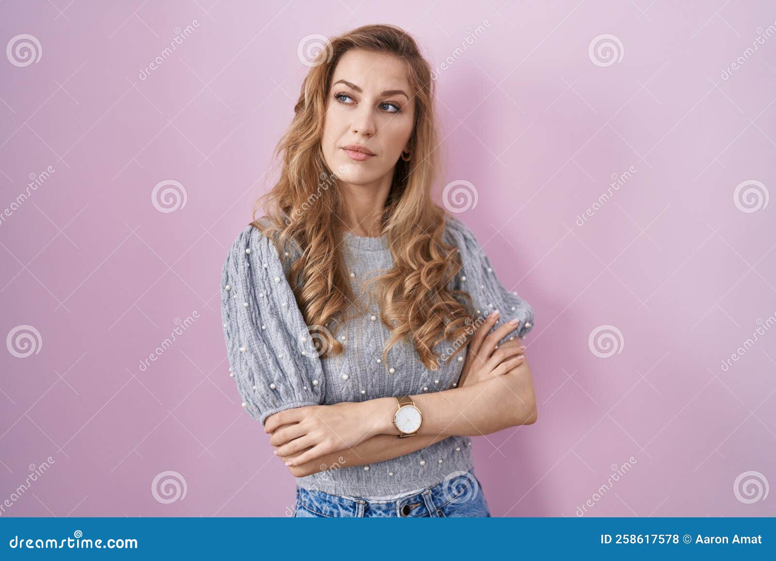 Beautiful Blonde Woman Standing Over Pink Background Looking To The