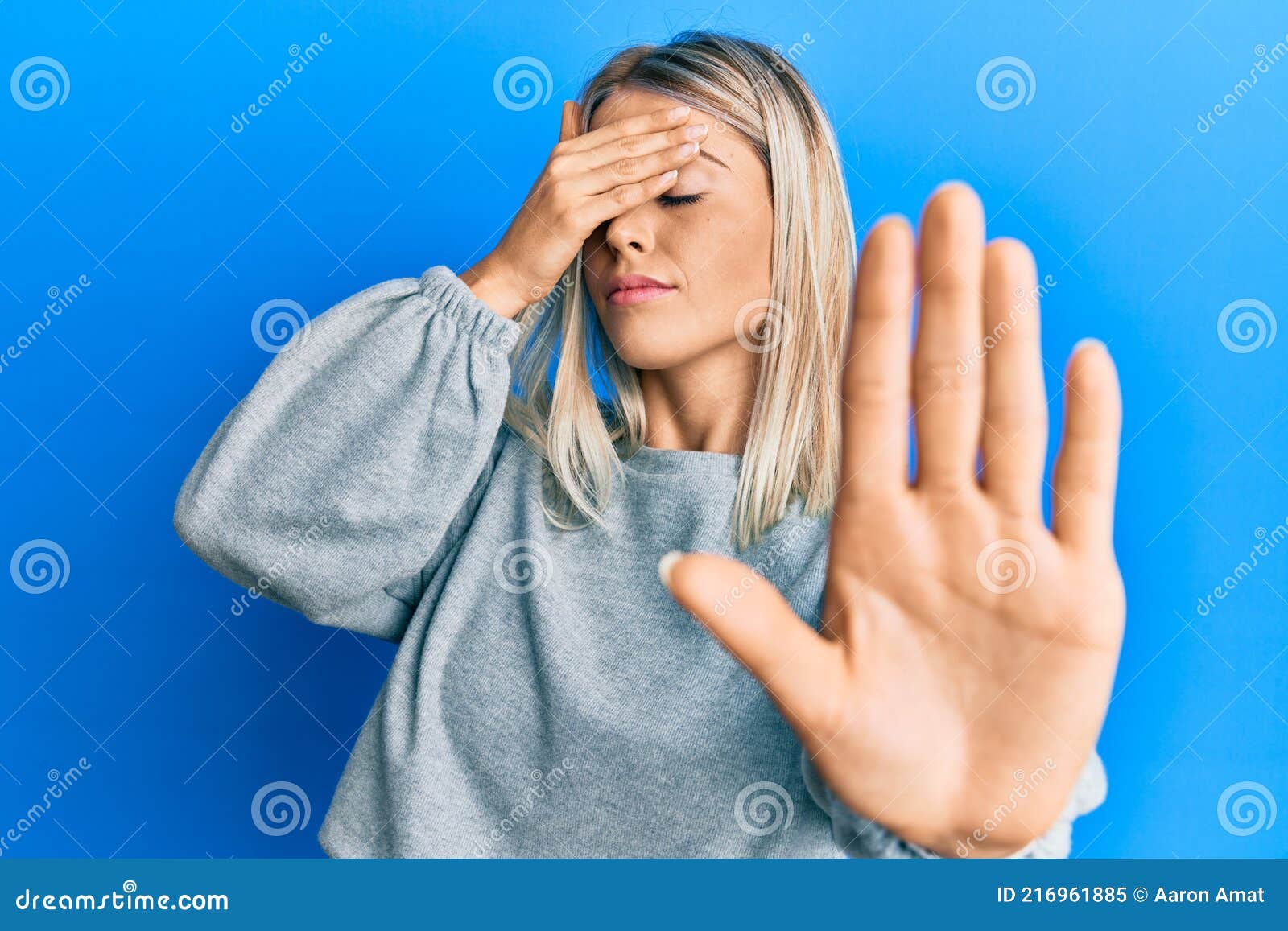 Beautiful Blonde Woman Wearing Casual Clothes Covering Eyes With Hands