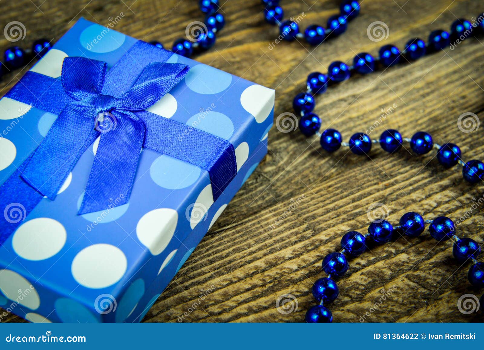 Beautiful Blue a Present with Blue Beads on a Wooden Background Stock ...