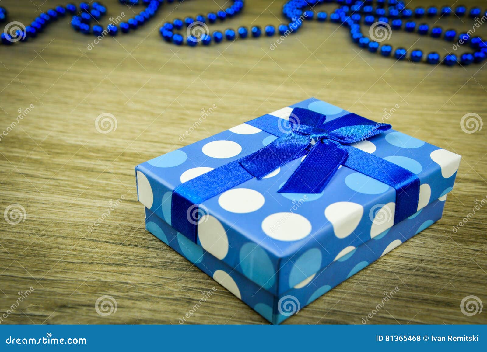 Beautiful Blue a Present with Blue Beads on a Wooden Background Stock ...