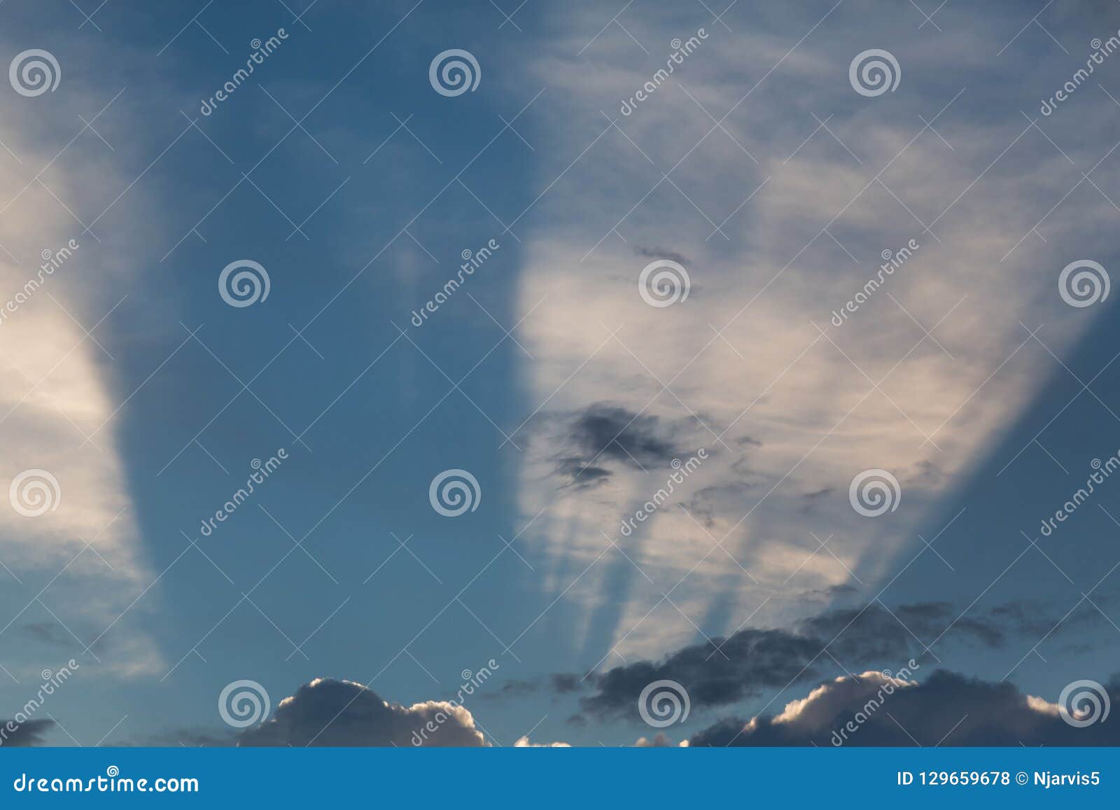 Beautiful Blue Sky with Sun Rays Emerging Behind the Clouds Stock Photo ...