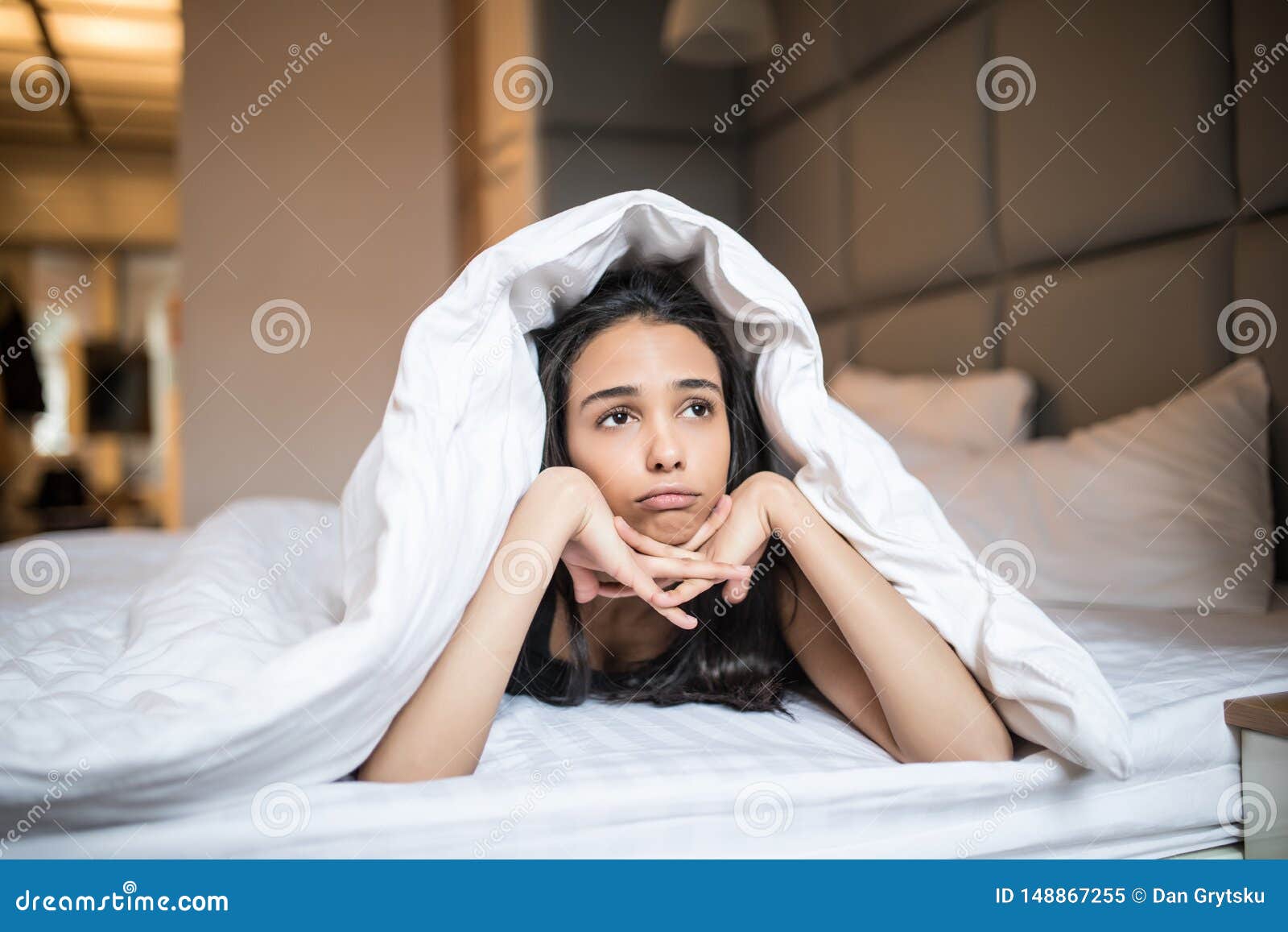 Beautiful Bored Mixed Race Woman Lies In Bed Under Blanket At Home