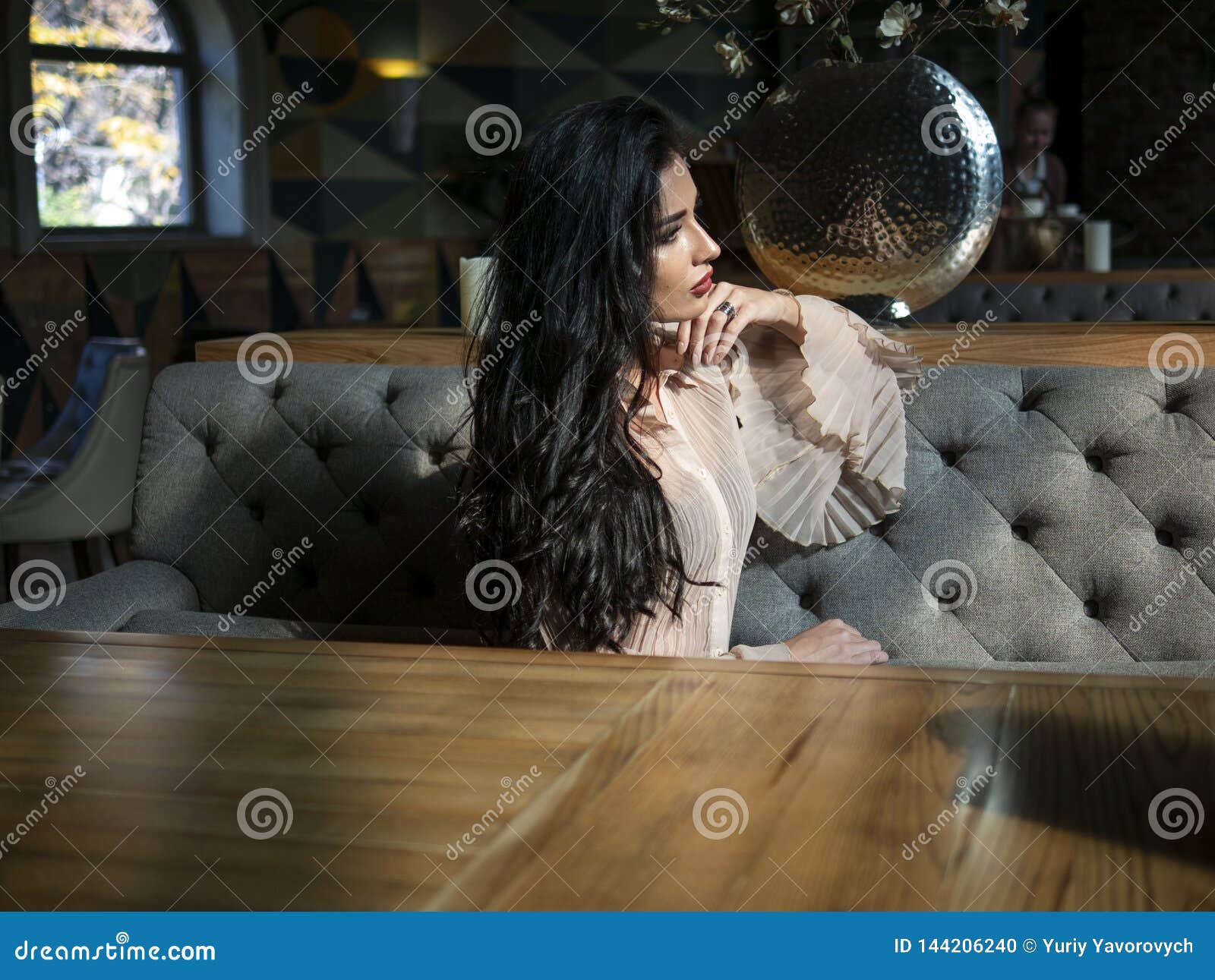 Beautiful Brunette Model Sitting on a Table in a Restaurant and Posing ...