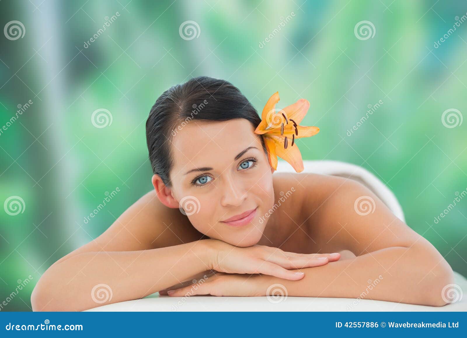 Beautiful Brunette Relaxing On Massage Table Smiling At Camera Stock