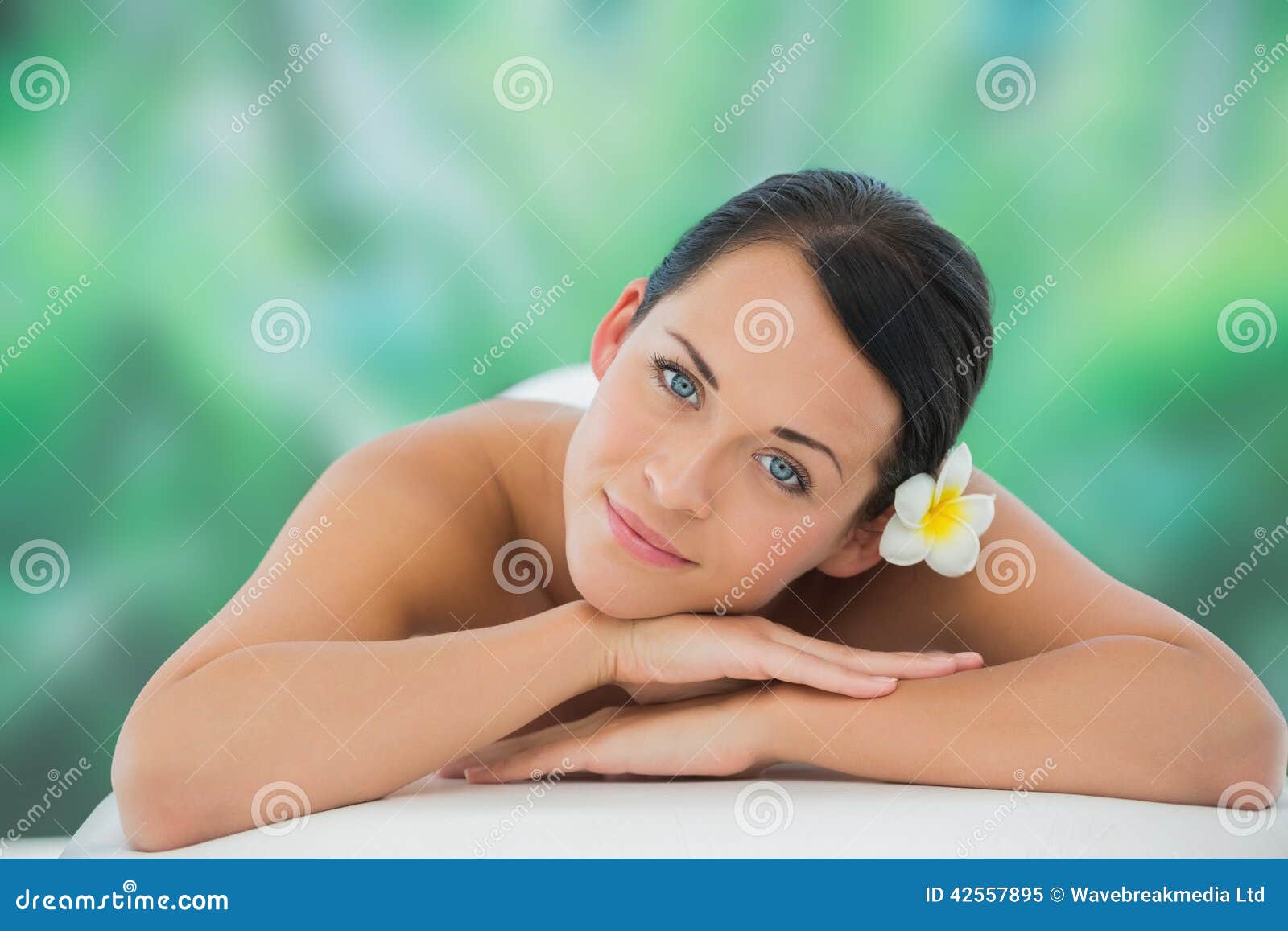 Beautiful Brunette Relaxing On Massage Table Smiling At Camera Stock