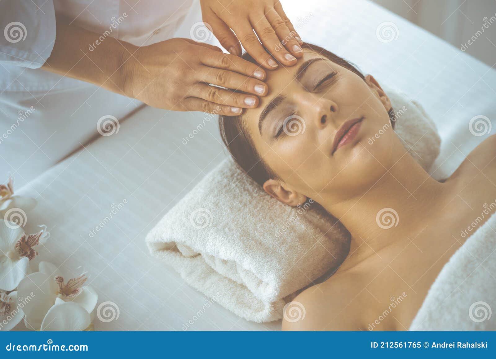 Beautiful Brunette Woman Enjoying Facial Massage With Closed Eyes In
