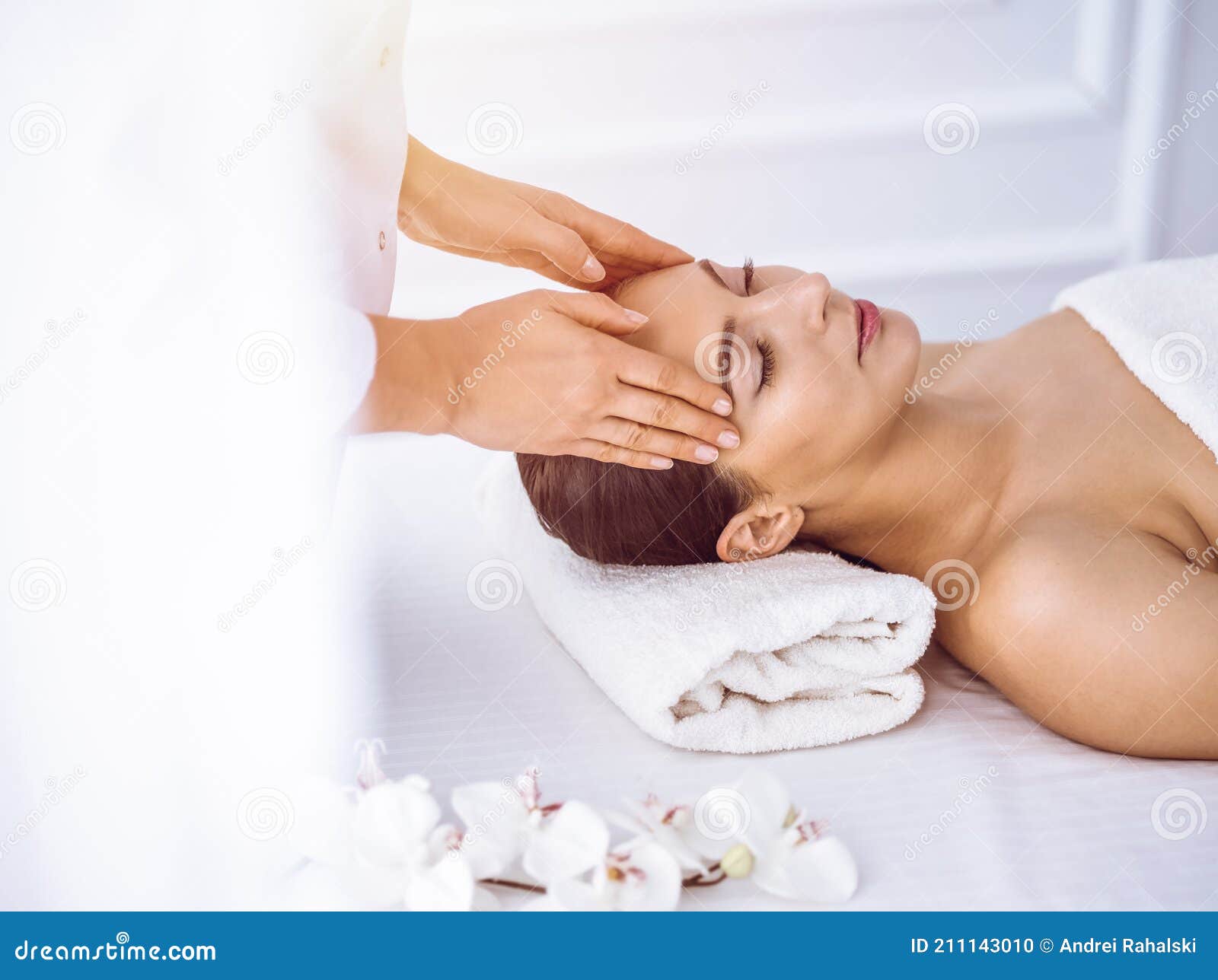 Beautiful Brunette Woman Enjoying Facial Massage With Closed Eyes In