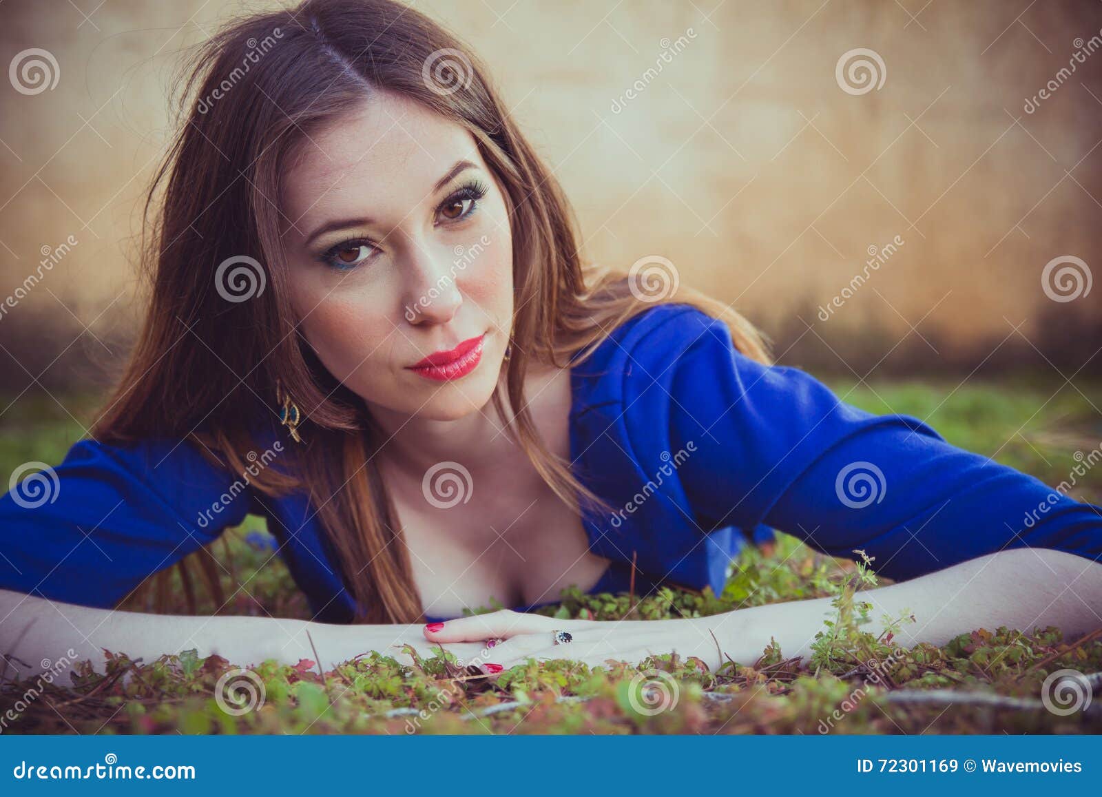 Beautiful Brunette Woman Lying On The Grass And Looking At The C Stock