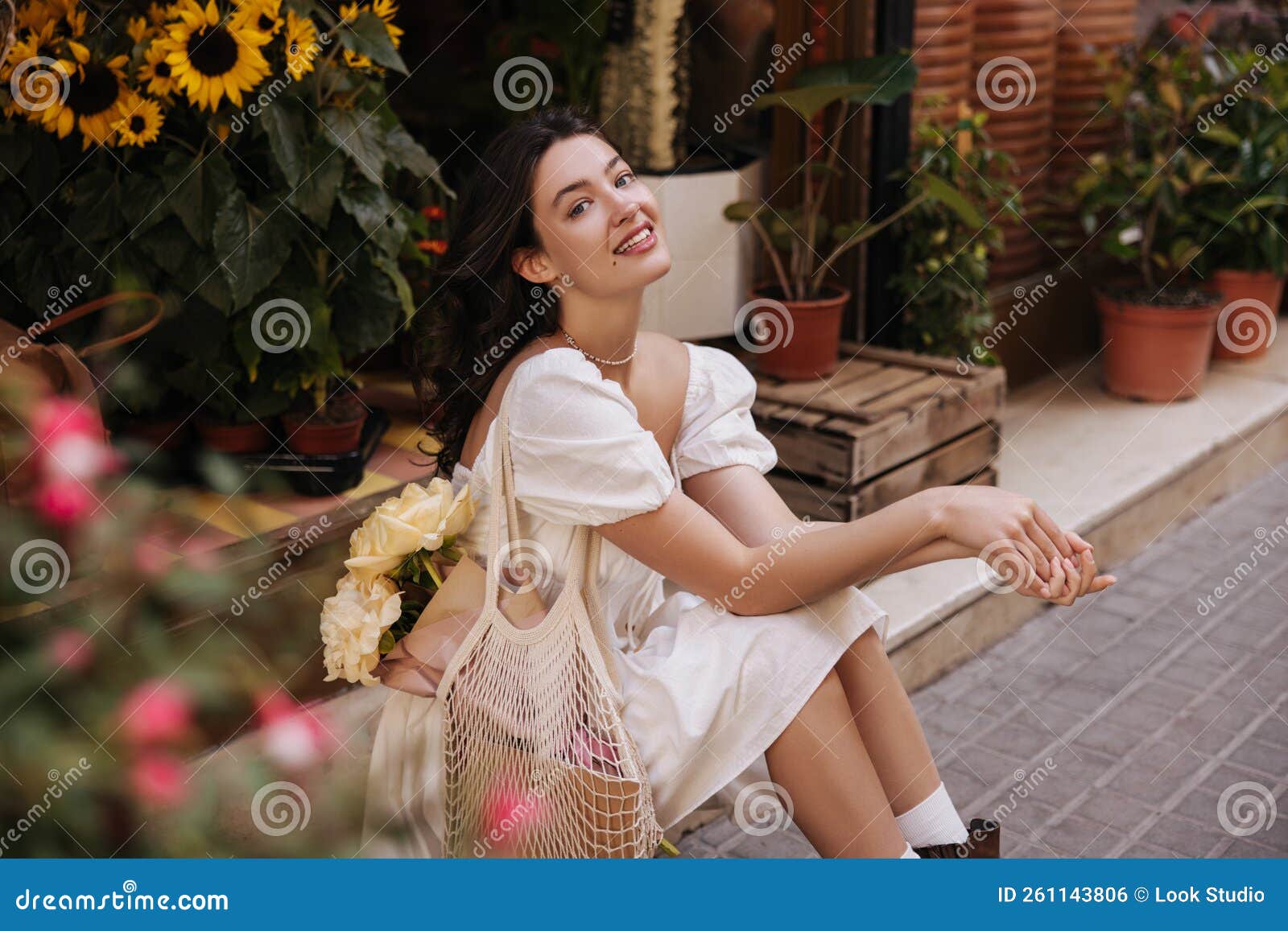 Beautiful Caucasian Young Woman Looking At Camera Sitting Outdoors