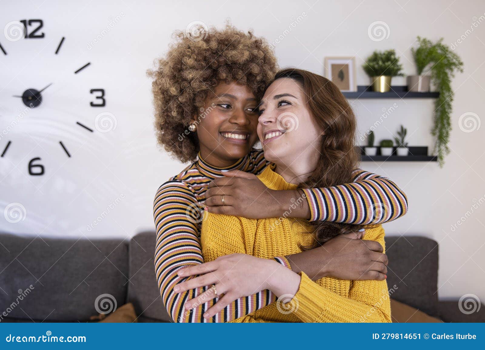 Beautiful And Cheerful Multiracial Lesbian Couple Hugging And Looking