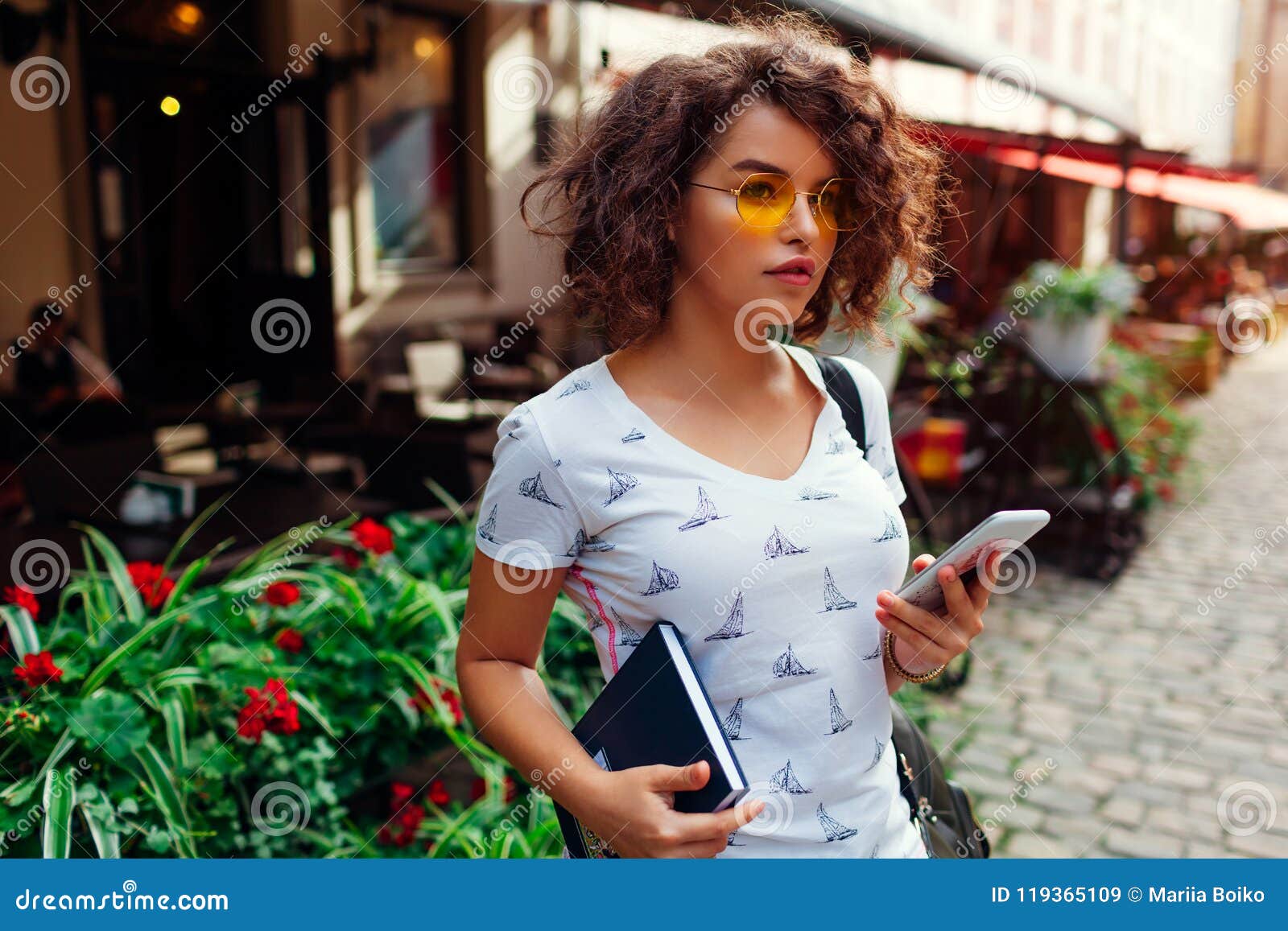 Beautiful College Girl Using Smart Phone And Holding Book Outdoors Stock Image Image Of