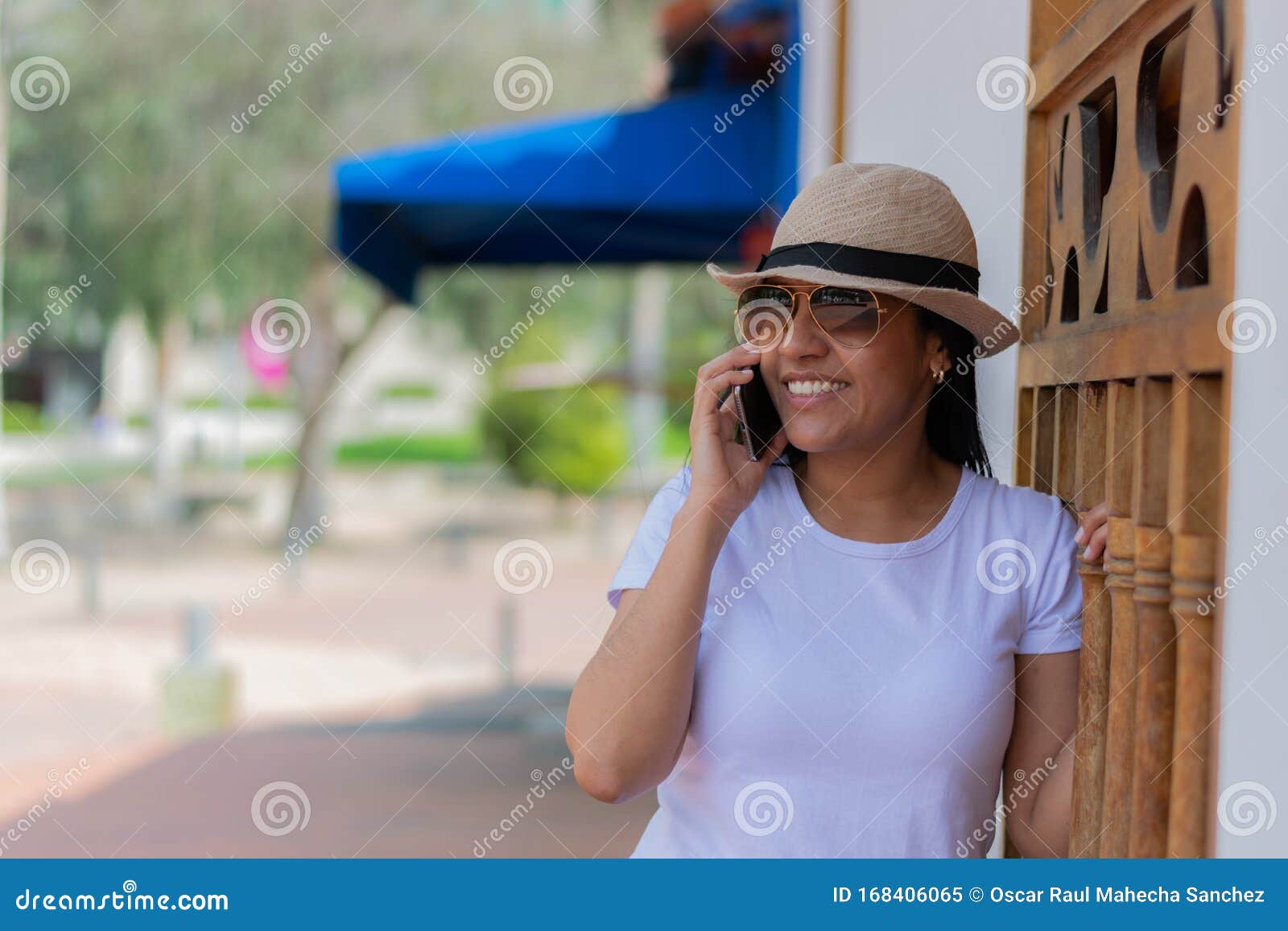 Beautiful Colombian Woman On Vacation With Sunglasses And Hat Talking