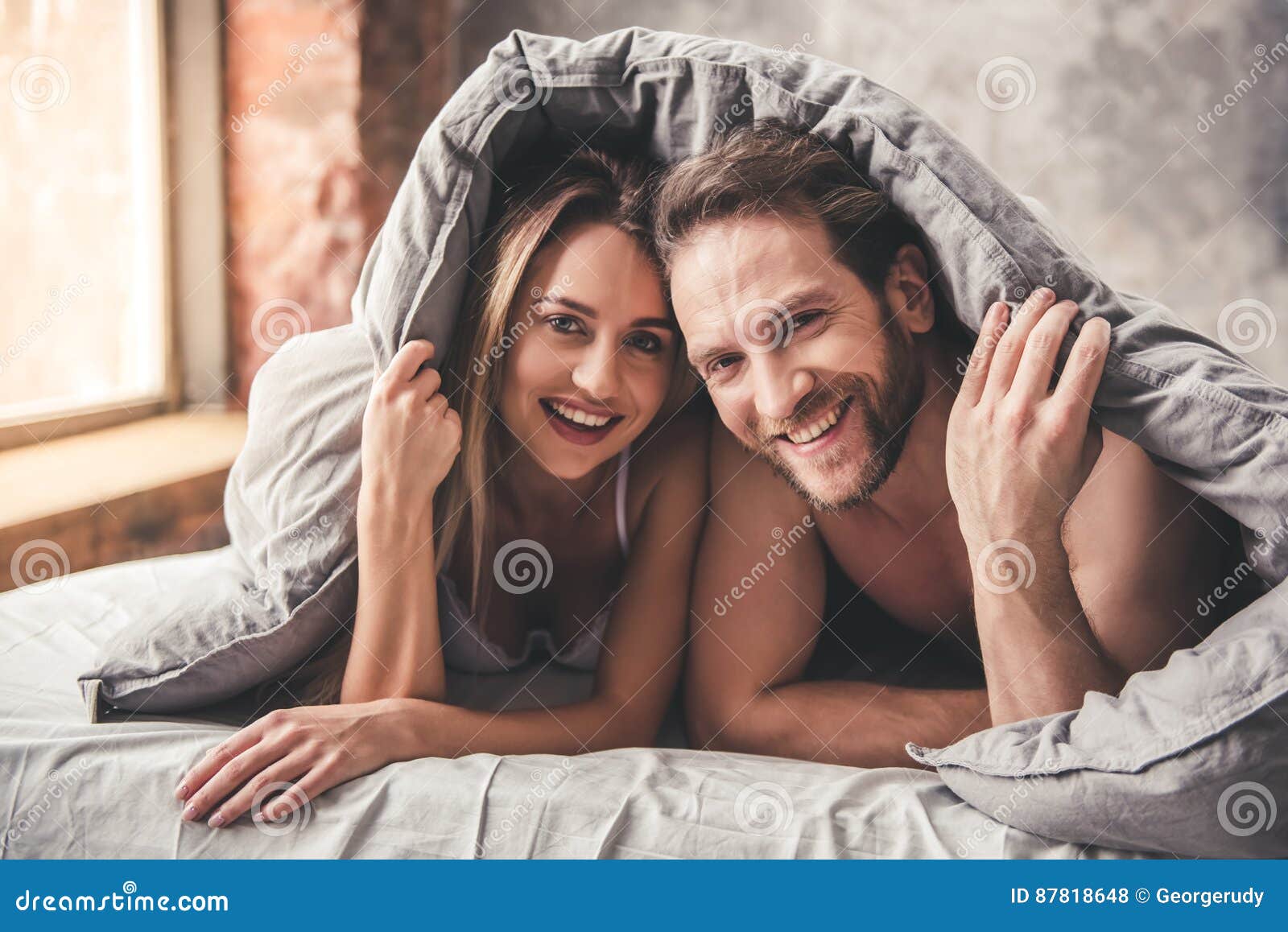 Beautiful couple in bed stock photo. Image of bedroom - 87818648