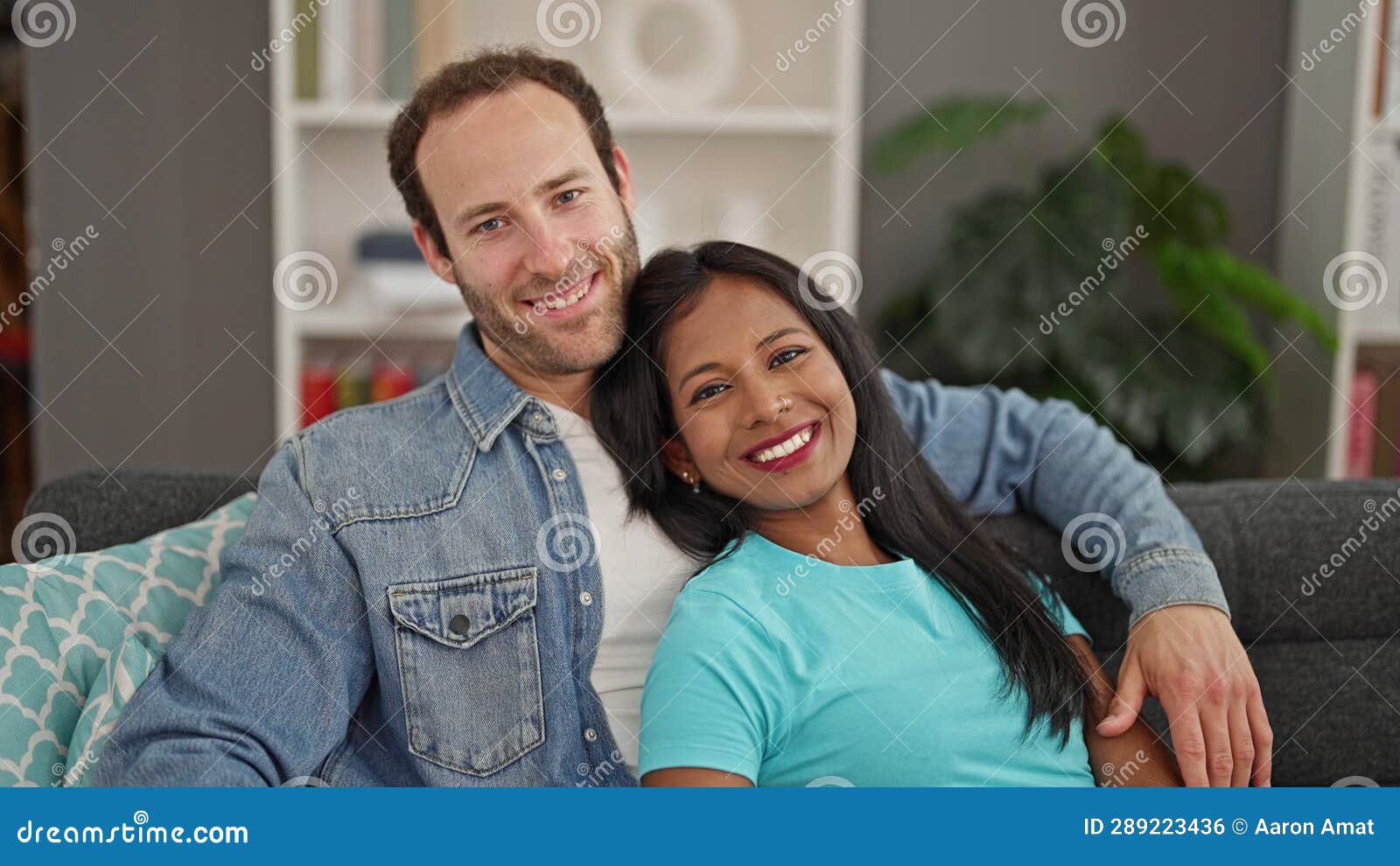 Beautiful Couple Hugging Each Other Sitting On Sofa Smiling At Home