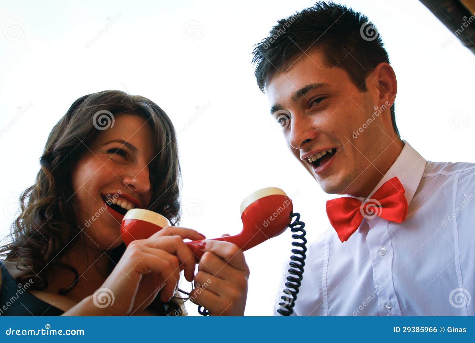 Beautiful Couple Talking into a Red Telephone Stock Photo - Image of ...