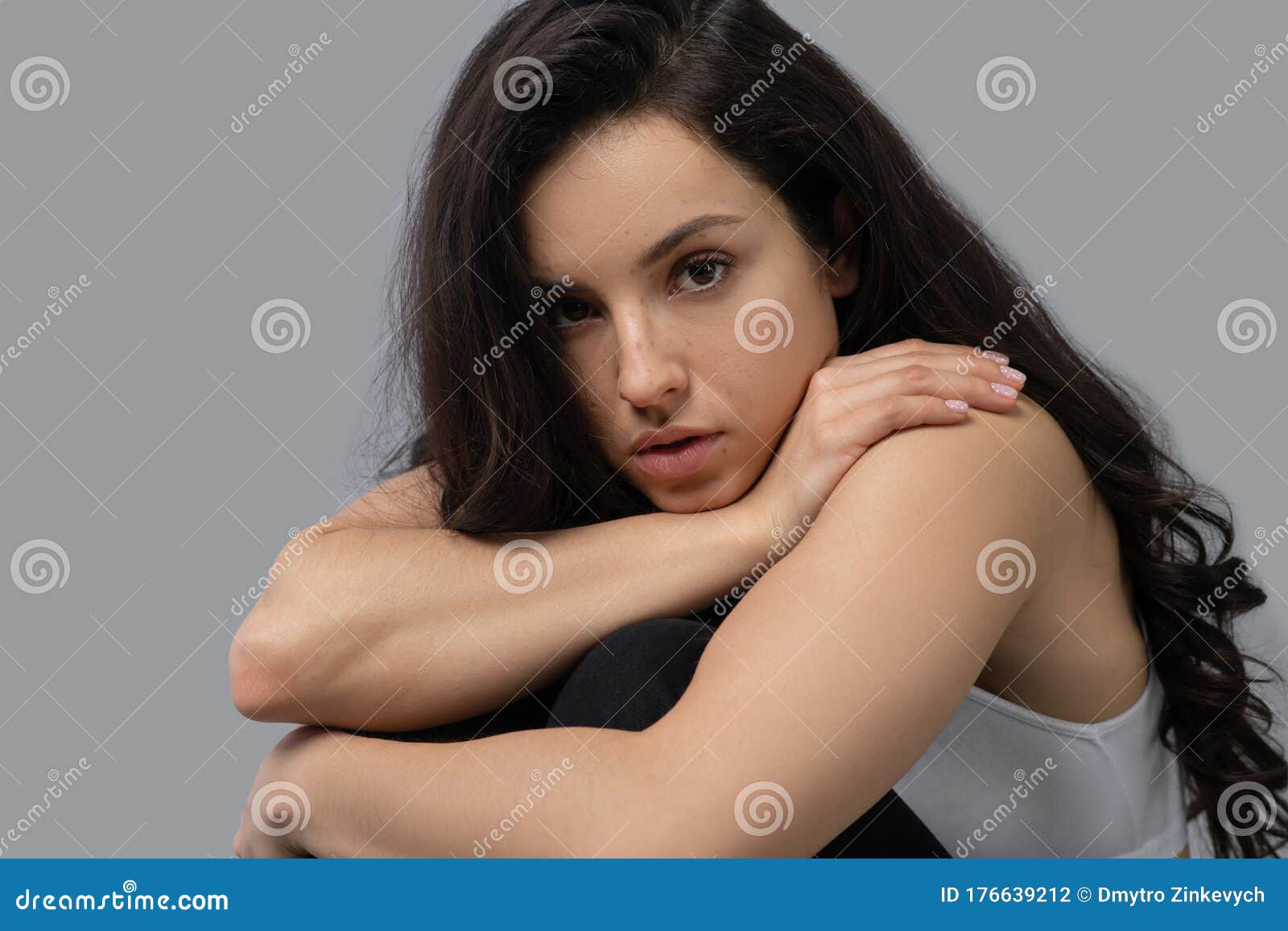Beautiful Dark Haired Girl In A White Top Looking Thoughtful Stock