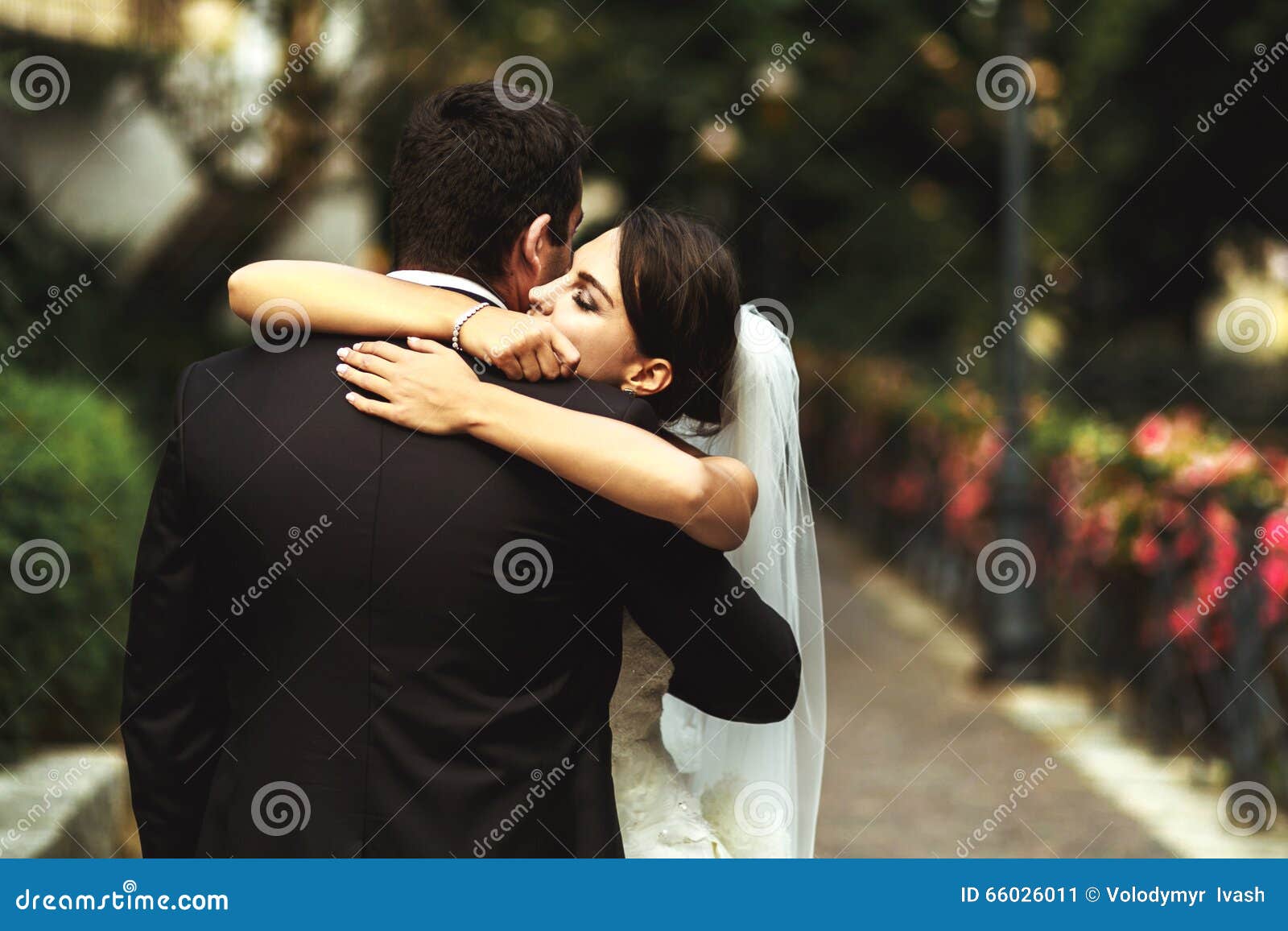 Beautiful Exotic Brunette Bride Hugging Handsome Groom In Park N Stock