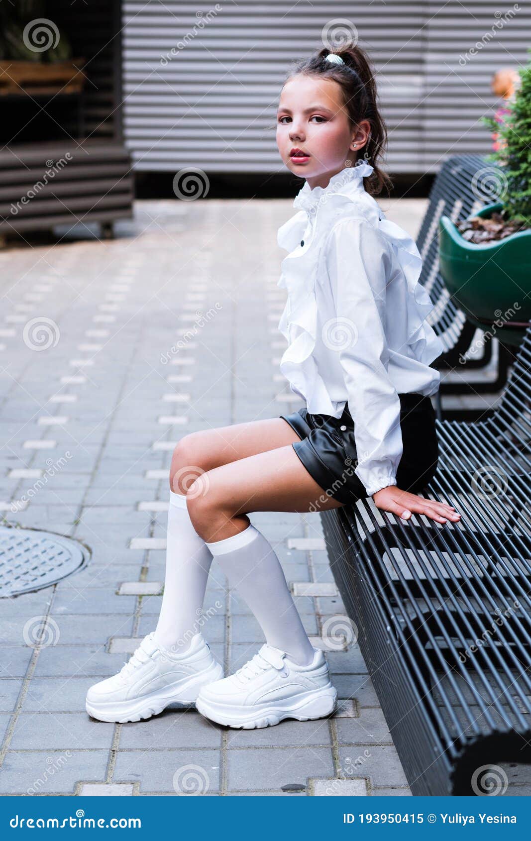 A Beautiful And Fashionable Schoolgirl In A White Blouse Black Shorts
