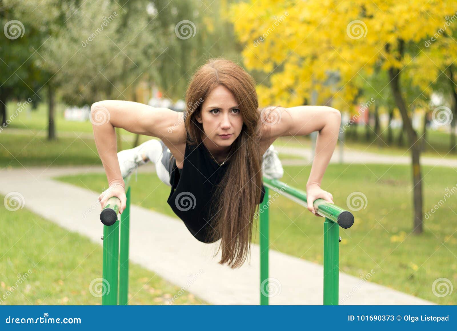 Beautiful Female Athlete Exercising on Parallel Bars, Doing Push-ups ...