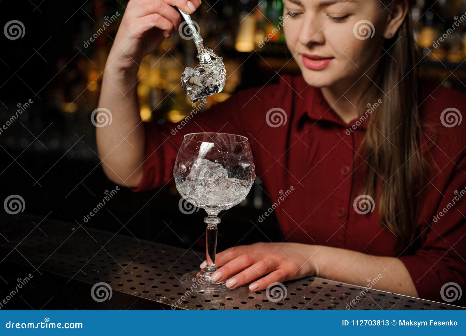 Beautiful Female Barman Putting Ice Cubes Into A Glass Making An Stock